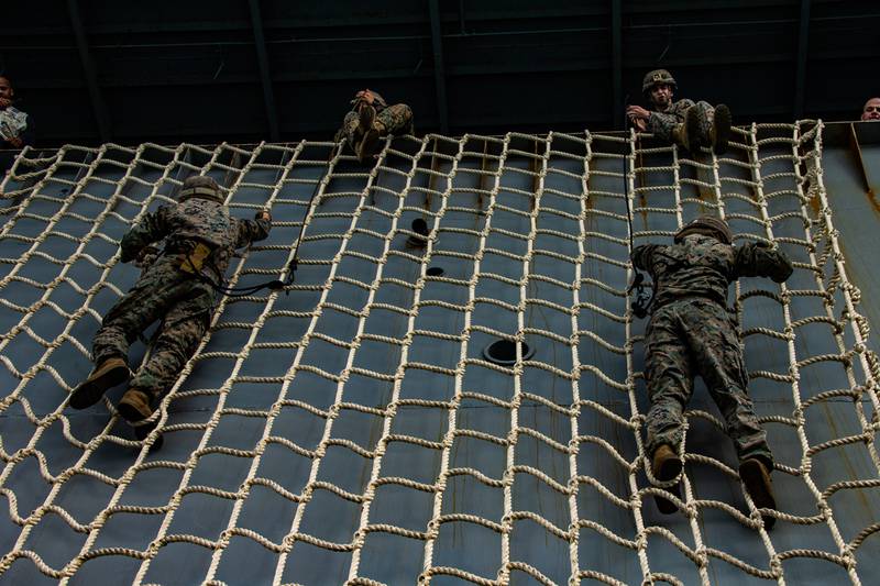 Marines descend down ship cargo net in tactic reminiscent of World War II